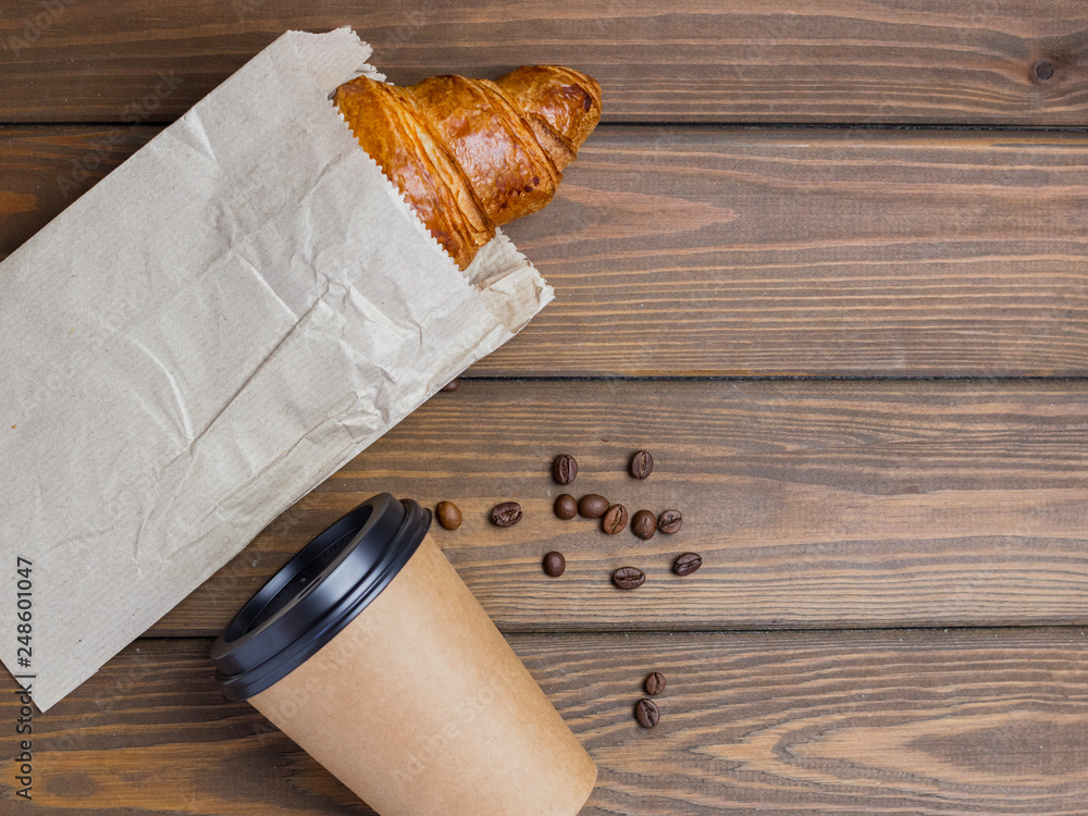 Coffee paper eco cup, beans and croissant in paper packaging on wooden ...