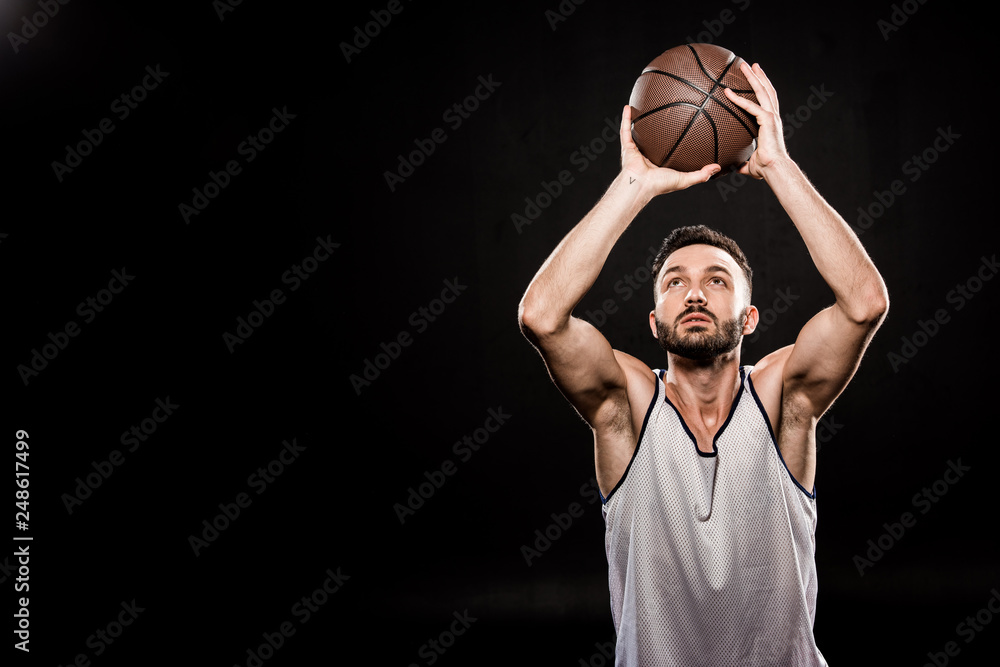 muscular basketball player throwing ball isolated on black Stock Photo ...