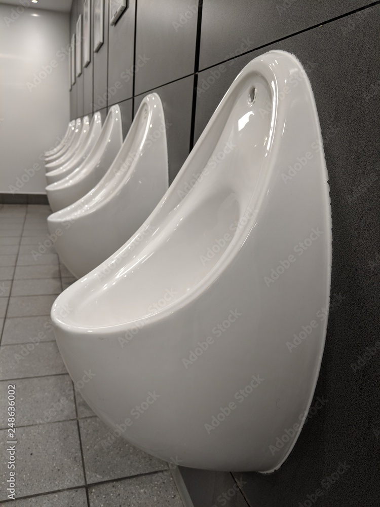 Row of shiny urinals in the gentlemen's toilets at a motorway service ...