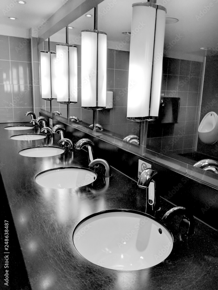 Row of shiny, contemporary, ceramic wash hand basins in front of a wall ...