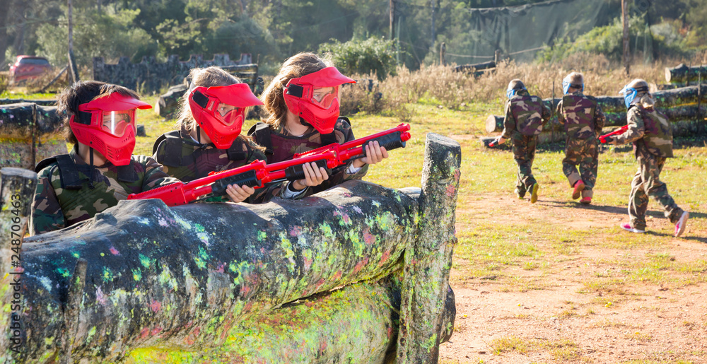 Opposing teams of happy kids shooting paintball Stock-Foto | Adobe Stock