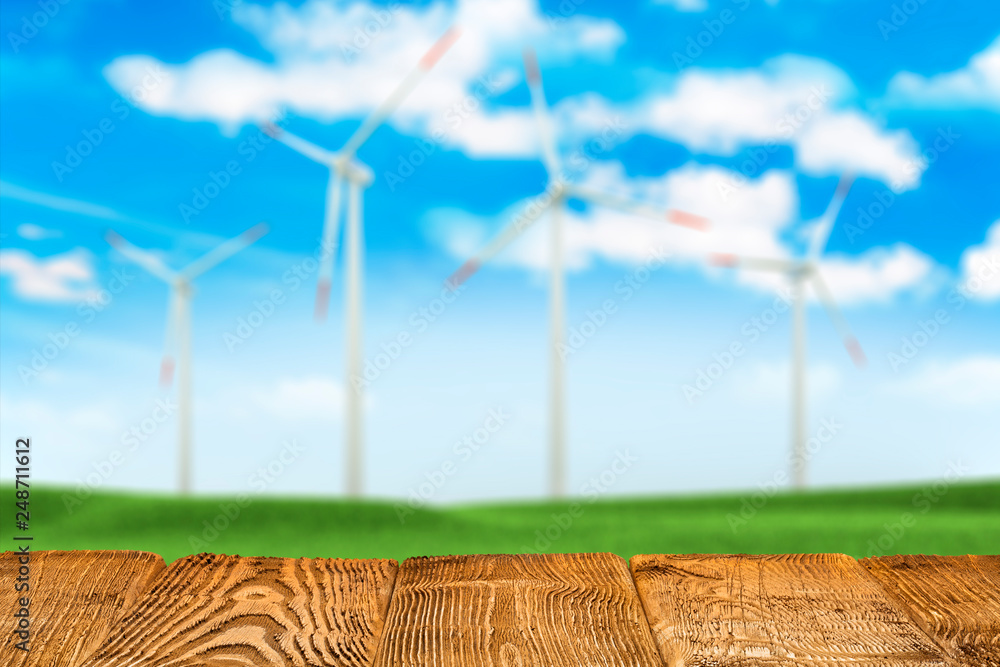 Wooden table with empty space on nature background with wind power ...