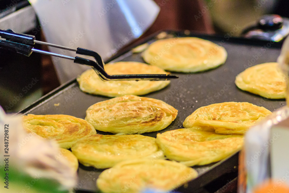 Foto de Close up vendor cooking for southern flat bread, mataba, or ...