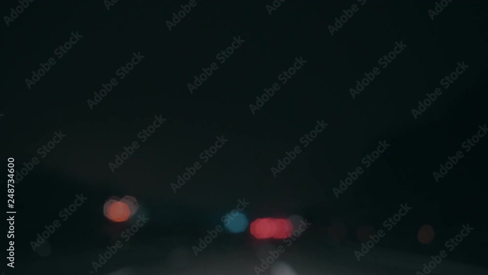 Blurred and unfocused big city lights, stop signals of overtaking cars ...