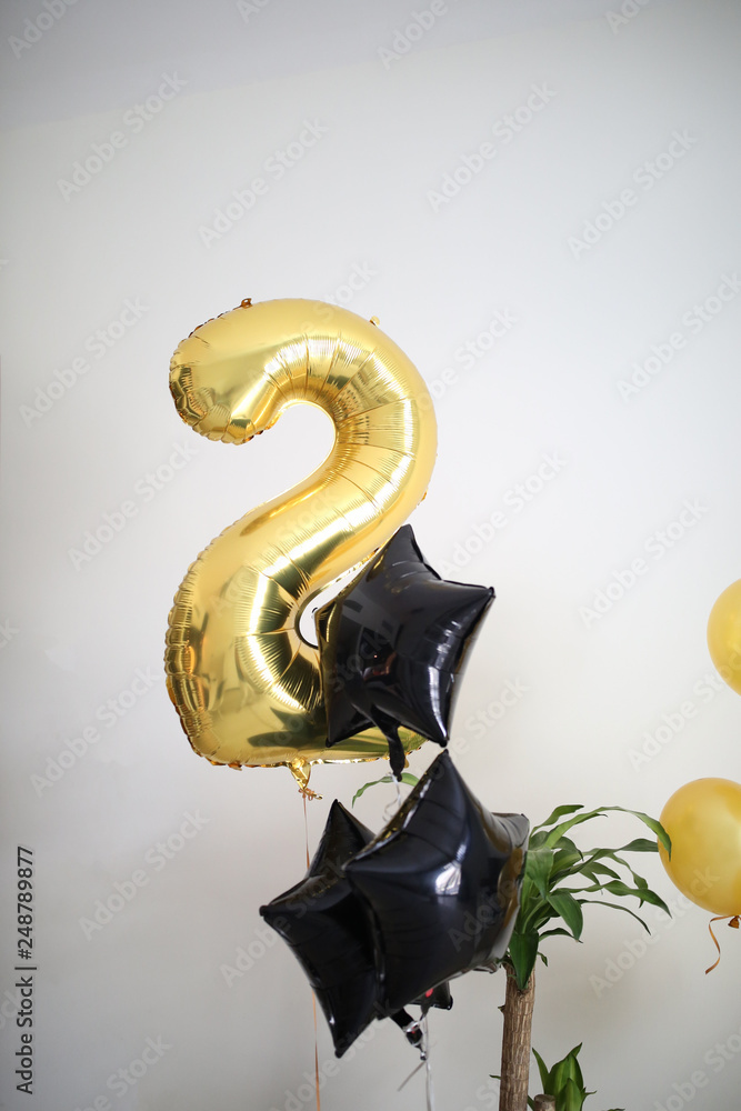 Gold air balloon number two and black shaped baloons stars , behind is ...