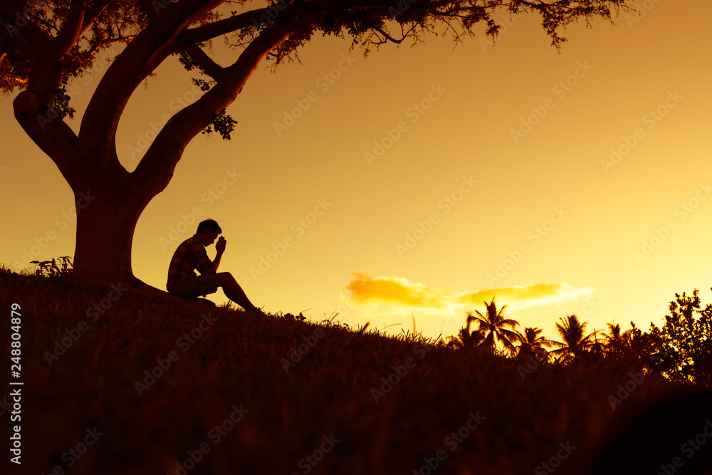 silhouette of a man praying at sunset Stock Photo | Adobe Stock