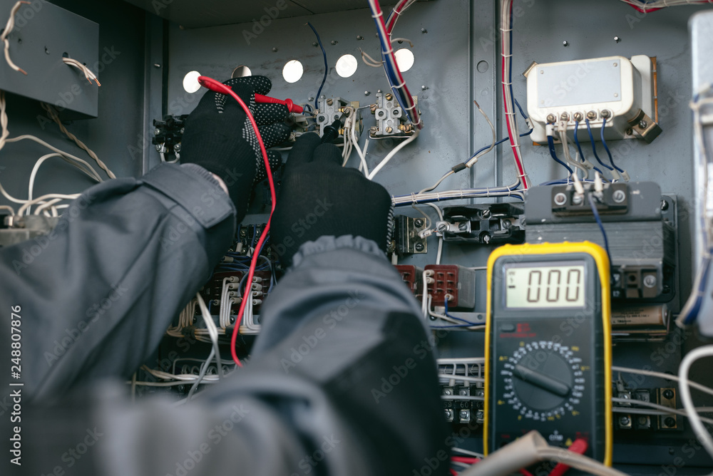 Electrician is checking the voltage in the electrical circuit of the ...