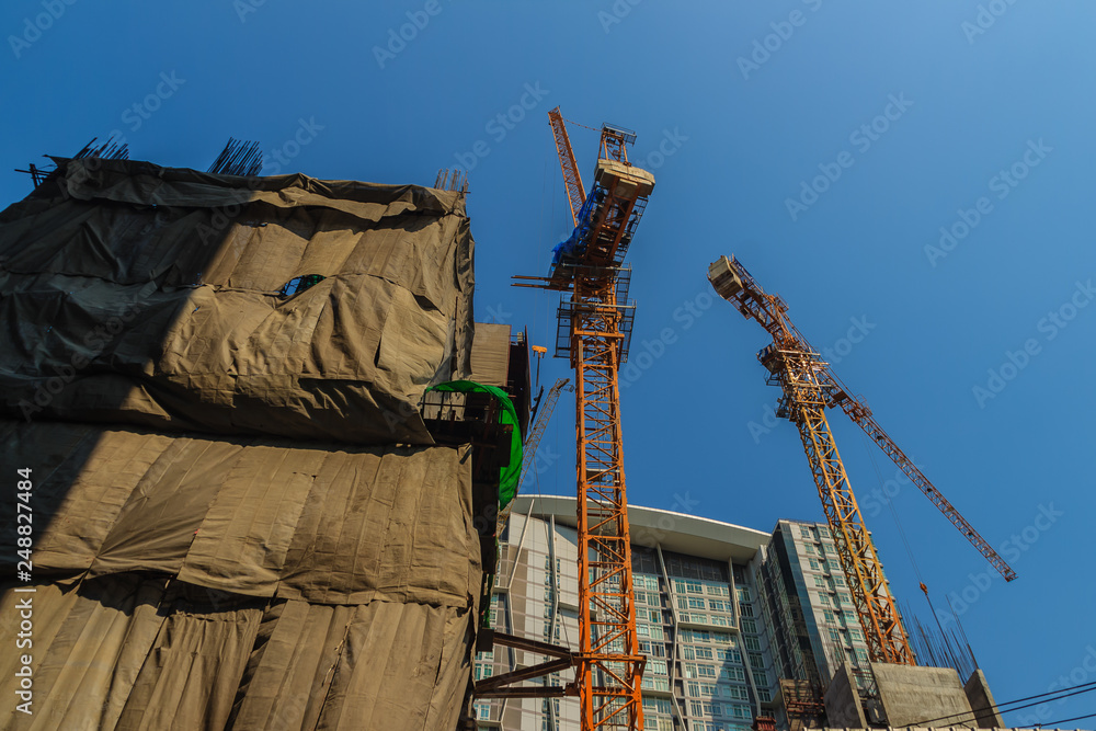 Luffing jib tower crane at condominium construction site over steel ...