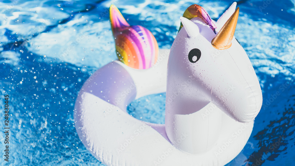 Inflatable colorful white unicorn at the swimming pool. Vacation time ...