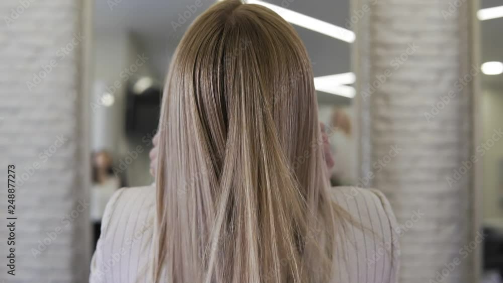 Attractive blonde woman tossing her long, wavy hair indoors in slow ...