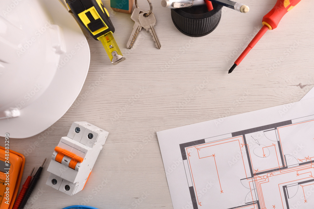 Office table of electrical engineer with installation project and tools ...