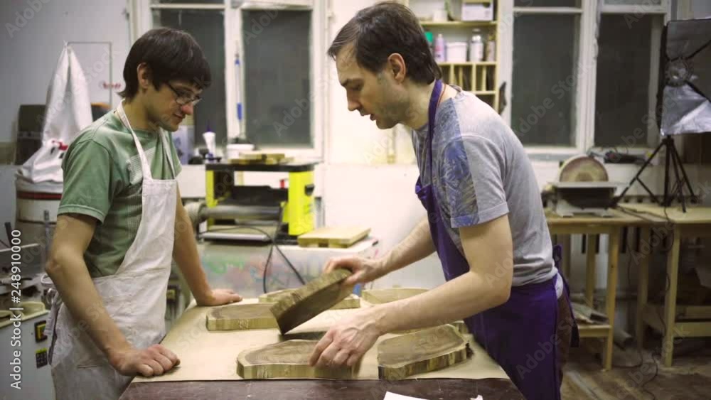 Two carpenters discuss wood blanks in the workshop Stock Video | Adobe ...