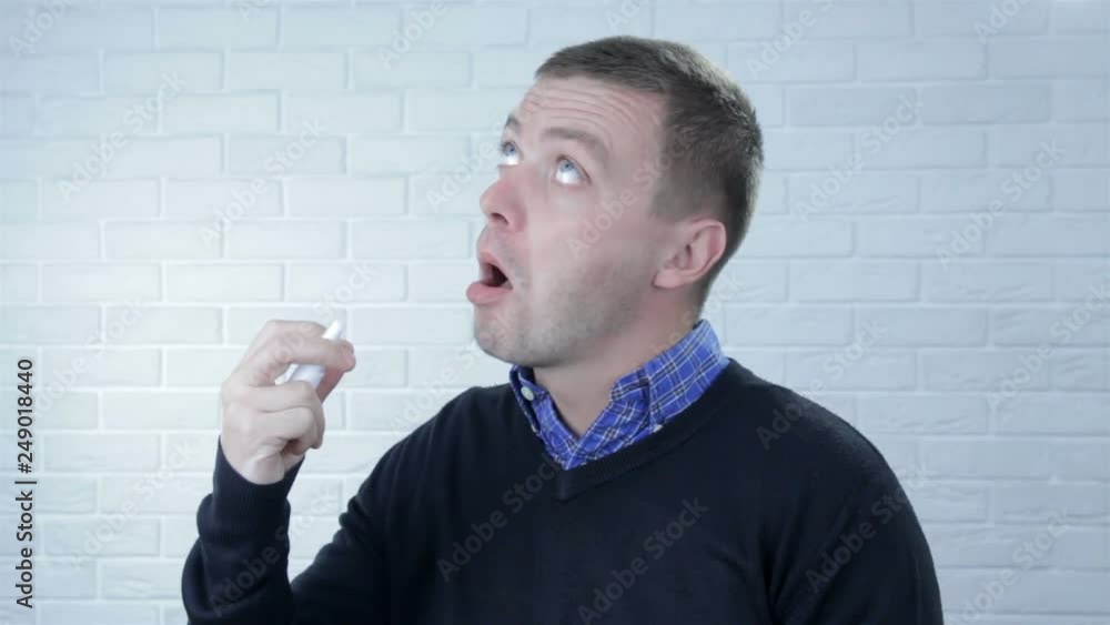 Illness and sickness. Handsome guy feeling sick dripping nasal drops in ...