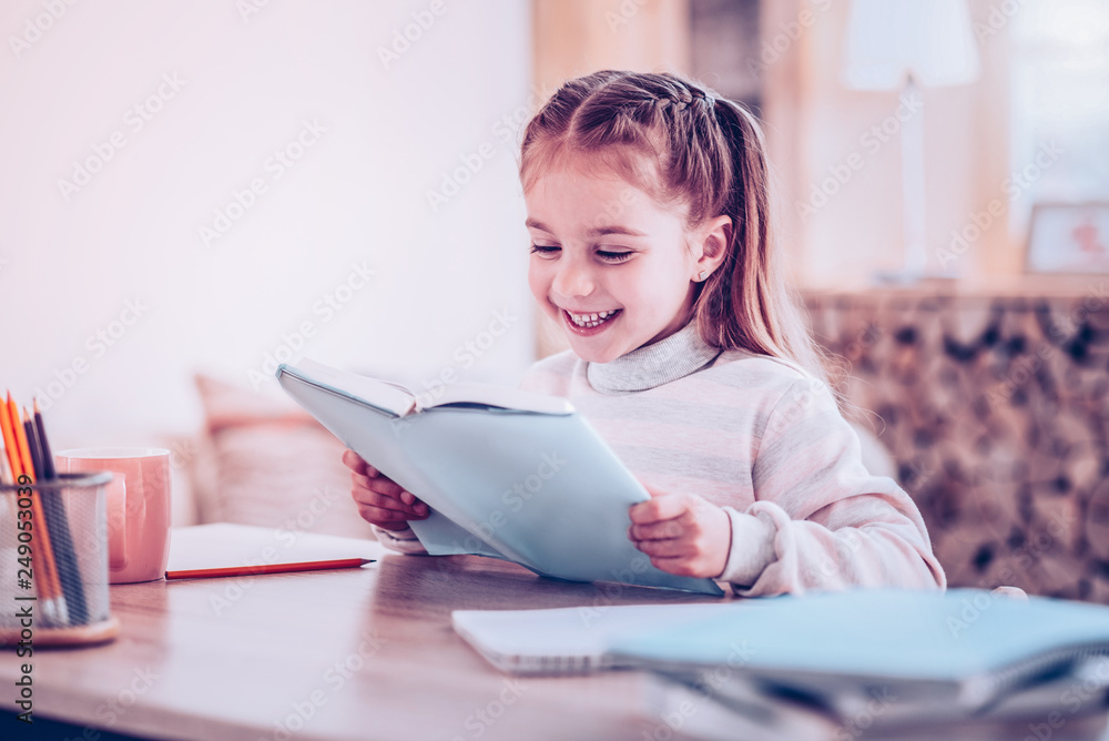 Lovely young child reading breathtaking adventure story Stock Photo ...