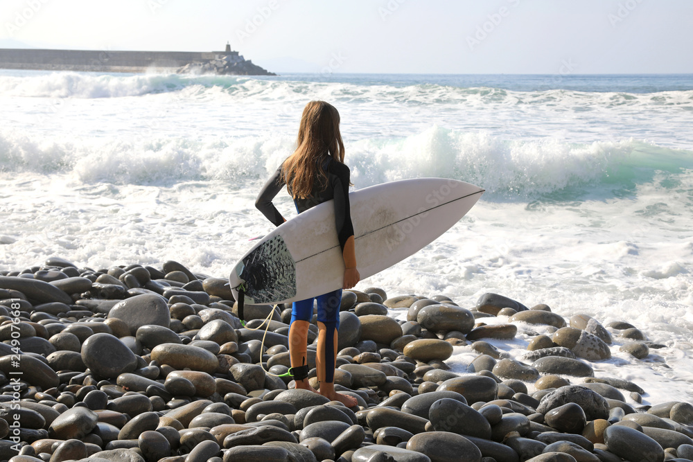 chica niña surfista con tabla metiendose en el agua surf país vasco ...