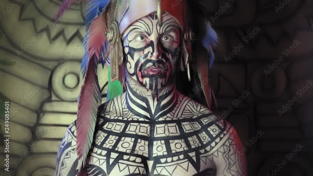 Ancient aztec warrior with crossed eyes, blood around his mouth and ...