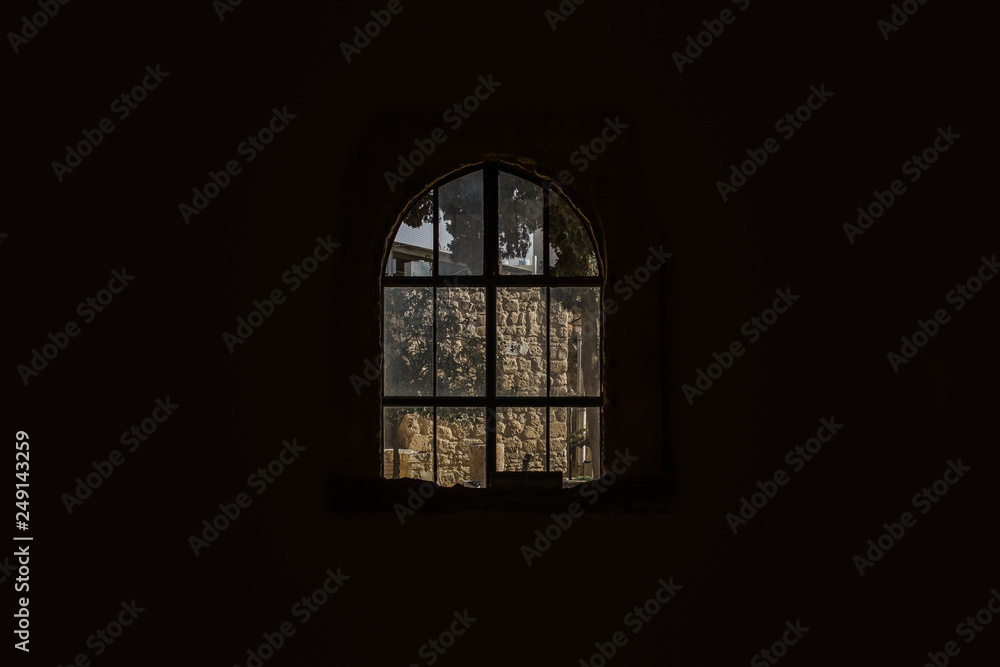 abandoned old arch window inside surrounded by deep black darkness ...