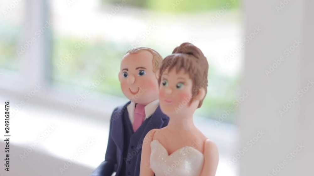 A close up shot of a wedding cake topper, focusing on the brunette ...