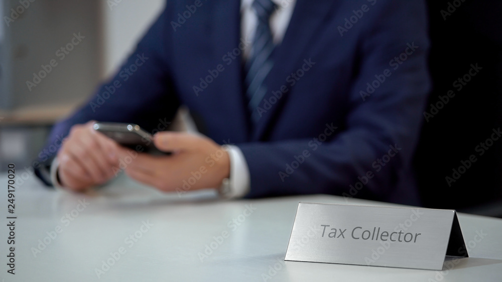 Busy male tax collector typing and sending messages to debtors from ...