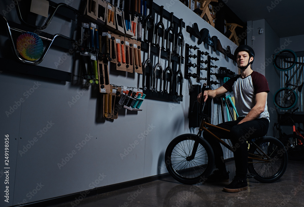 Professional BMX rider sitting on his bike next to a stand with BMX ...