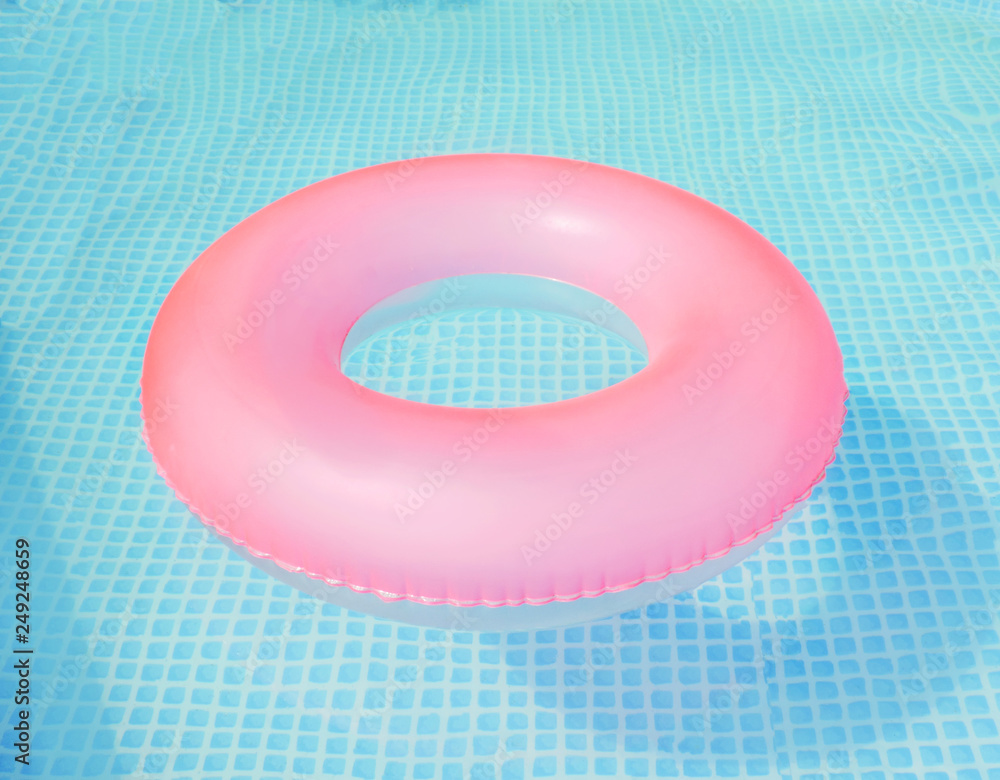Pink pool float, ring floating in a refreshing blue swimming pool ...