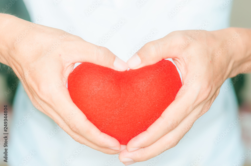 handsome man holding red heart in hands and making heart shape gesture ...