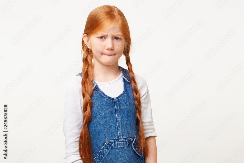 Emotional kid looks sad, displeased, expresses offense,crying, bites ...