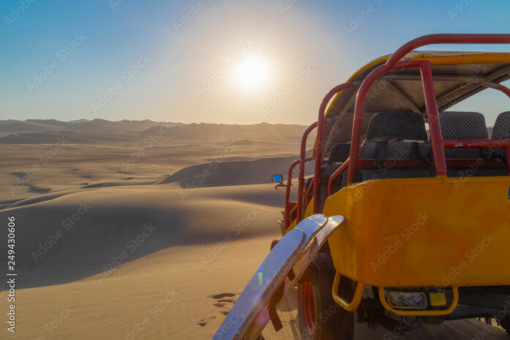 Sand boarding ,Dune Buggy parked in the desert during sunset at ...