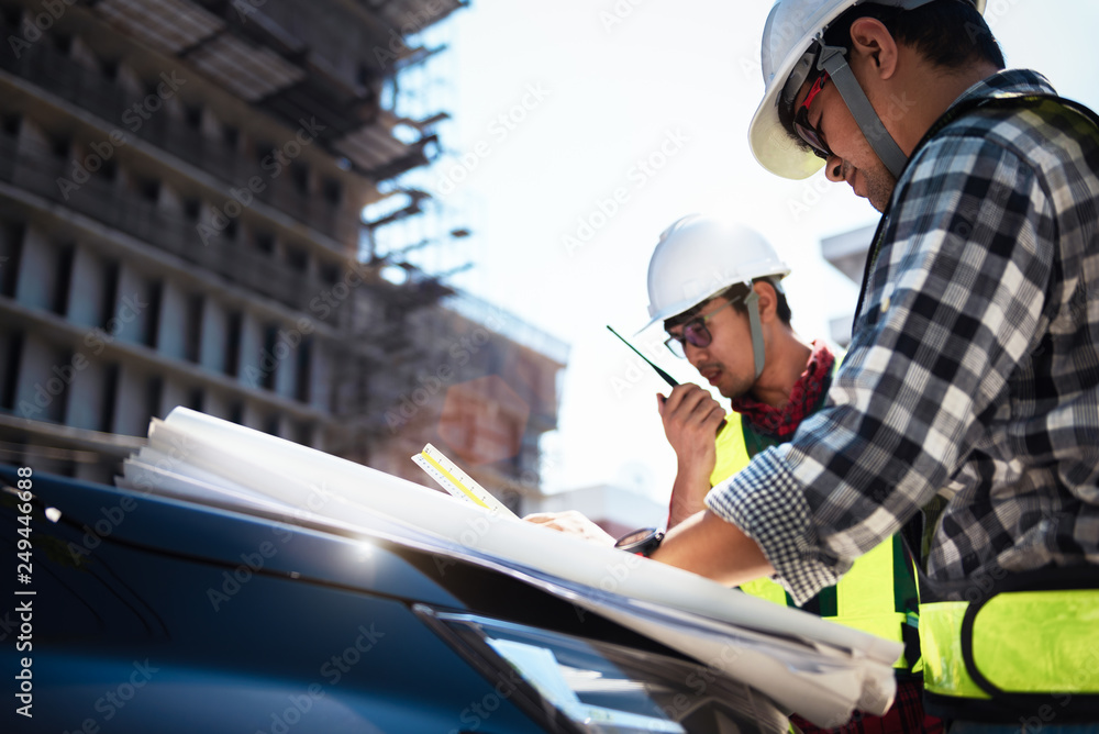 Construction engineers discussion with consultant at construction site ...