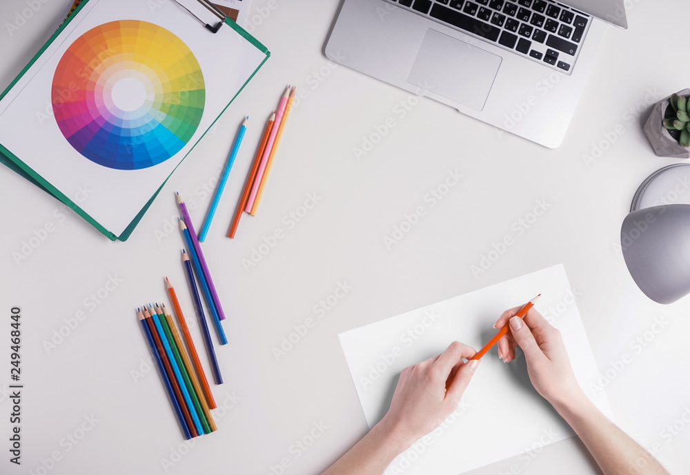 Female graphic designer with pencils, color palette and laptop on white ...