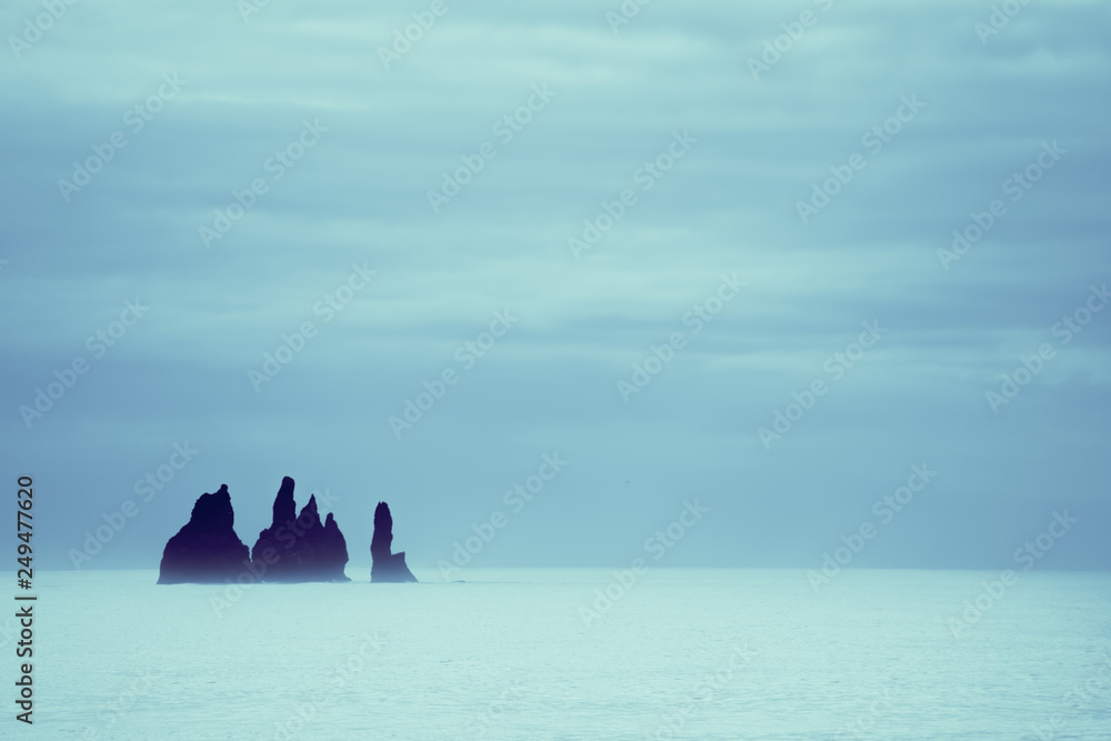 Famous basalt sea stacks of Reynisdrangar, rock formations on the black ...