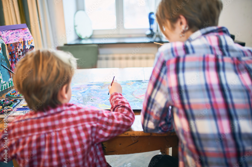 Cute happy little boy and teacher drawing in artist class. Education ...