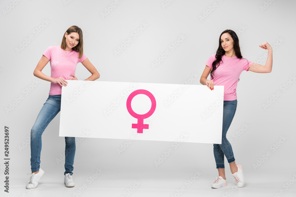 beautiful woman showing muscle and holding large sign with female ...