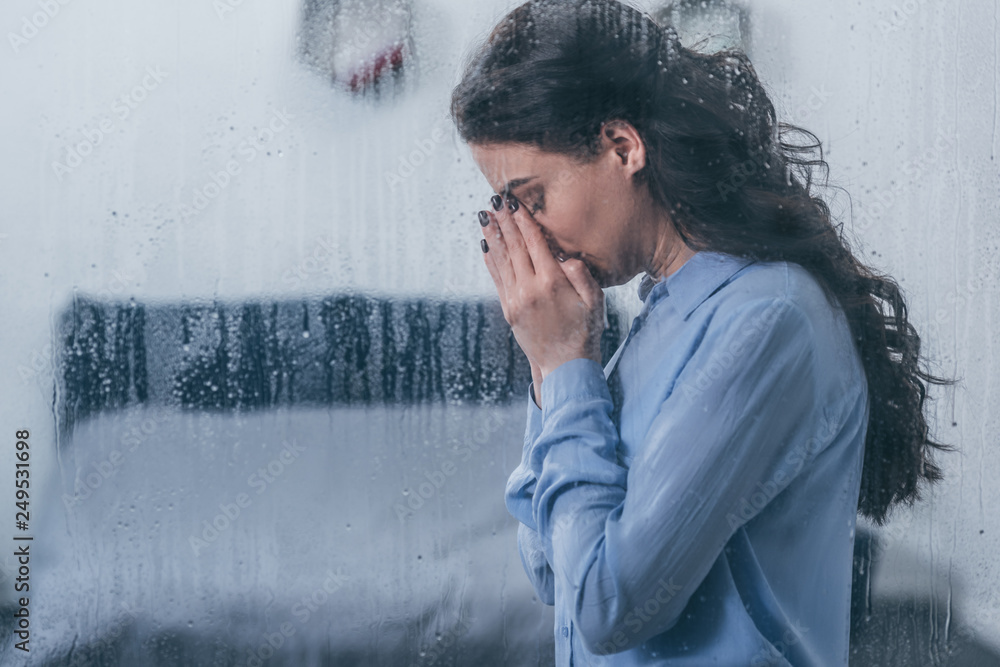 depressed woman covering face with hands and crying at home through ...