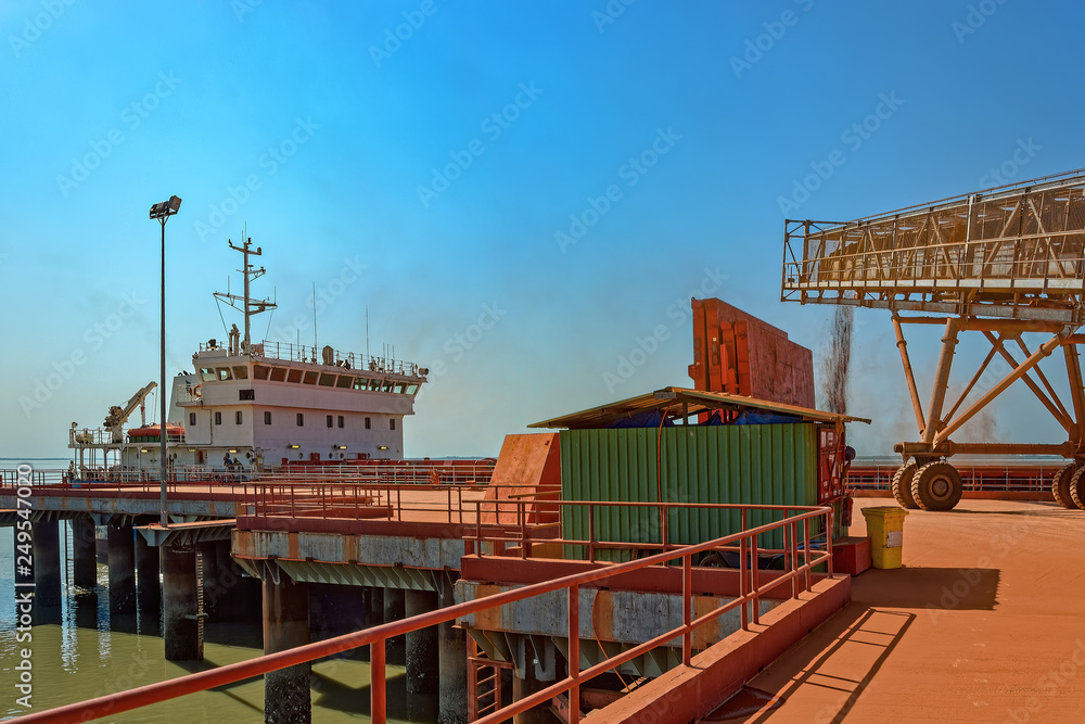 Conveyor belt loading bauxite aluminum ore into a capesize bulk carrier ...
