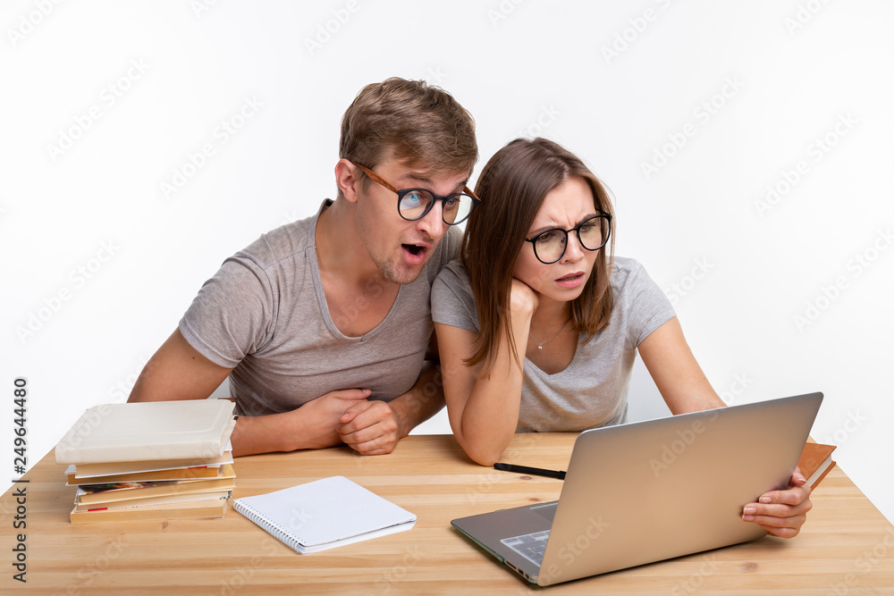 Nerds, study, people concept - a couple of people look at the laptop ...