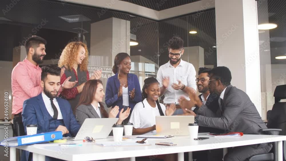 Positive team is clapping hands. Happy young active office workers ...