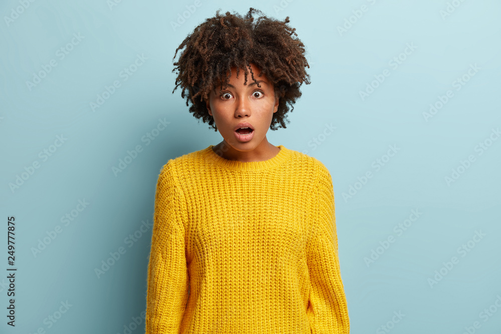 Bewildered young woman keeps jaw from astonishment, opens eyes widely ...