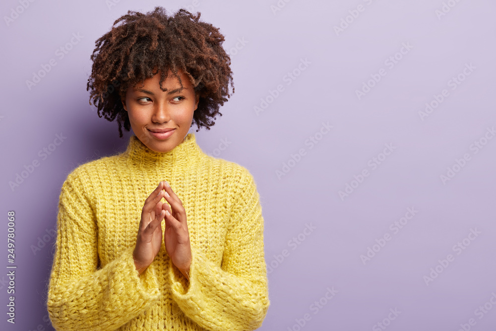 Studio shot of tricky black woman keeps hands in intruguing gesture ...