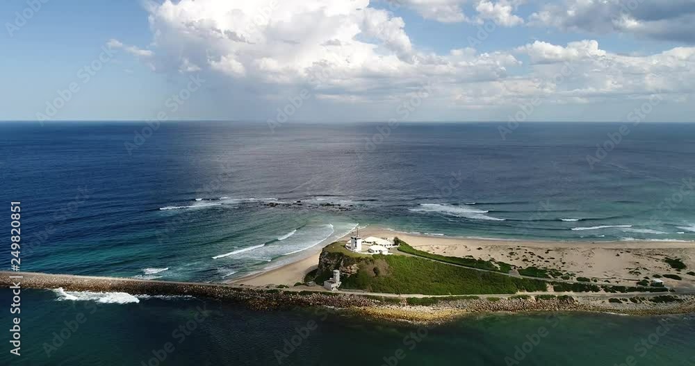 Nobbys head lighthouse on the top of the hill and sandy cape breacking ...