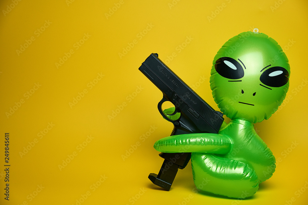 green alien looks,yellow background, green alien with gun Stock Photo ...