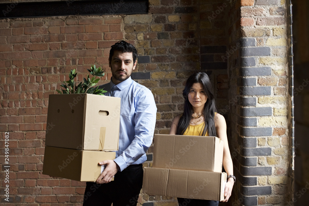 Portrait of male and female co-workers moving in to a new office Stock ...