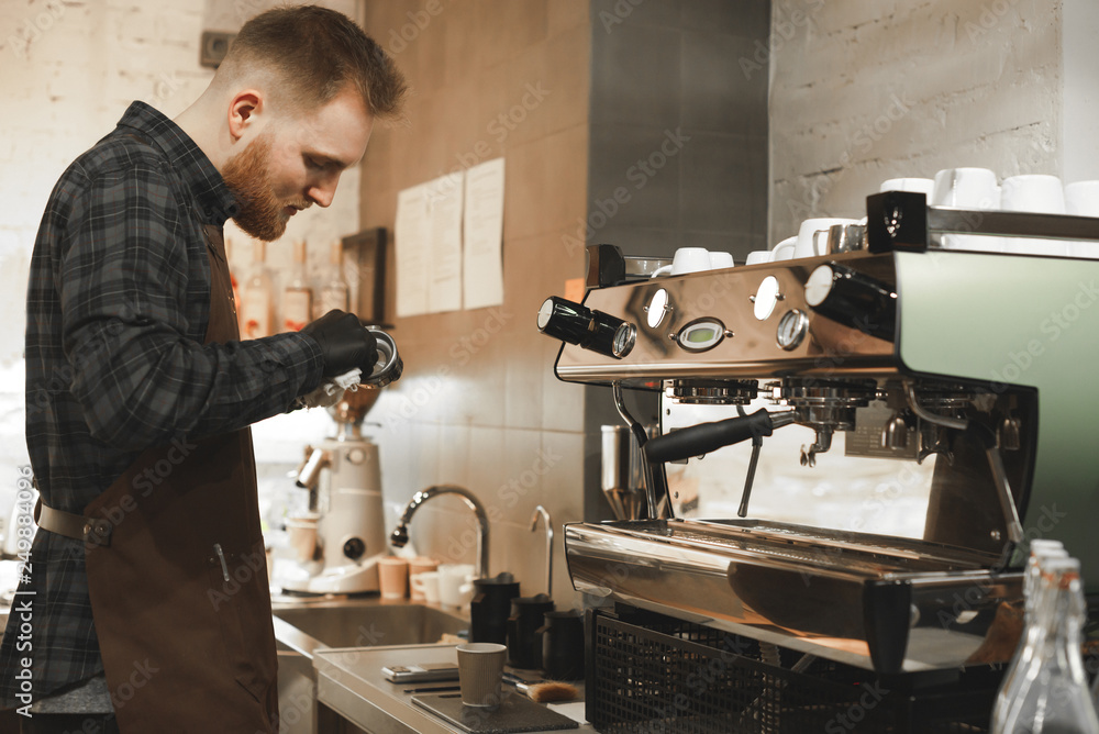 Barista cleaning the portafilter on a shiny espresso machine at the ...