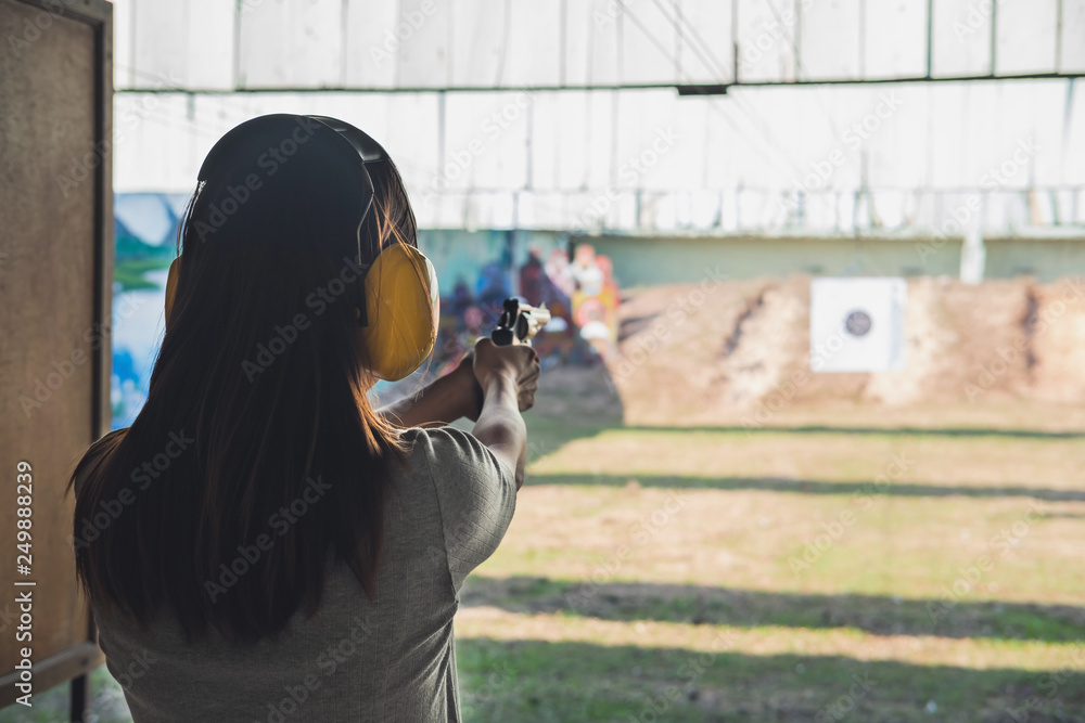 Young woman practice gun shoot on target Stock Photo | Adobe Stock