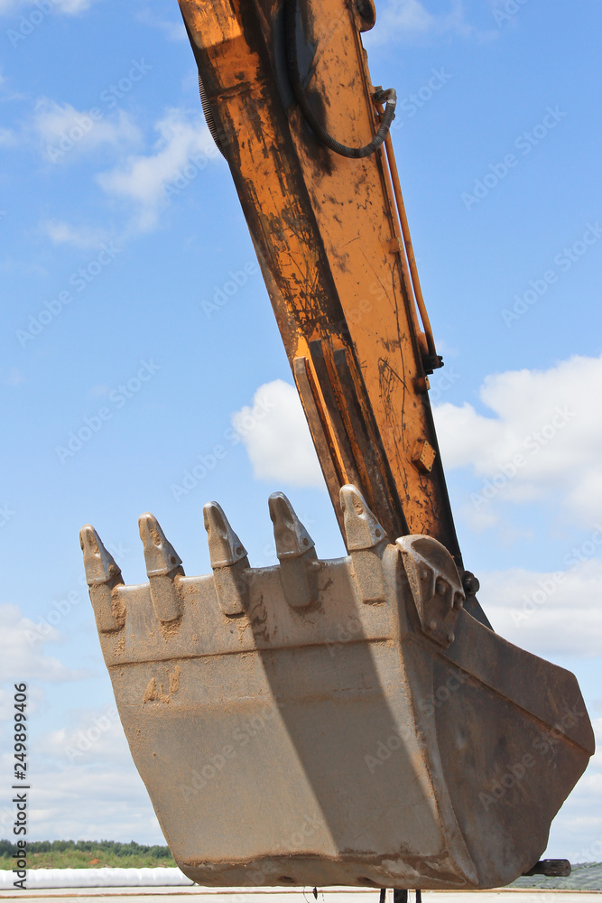 Excavator working on earthworks. Large excavator bucket close-up. Part ...