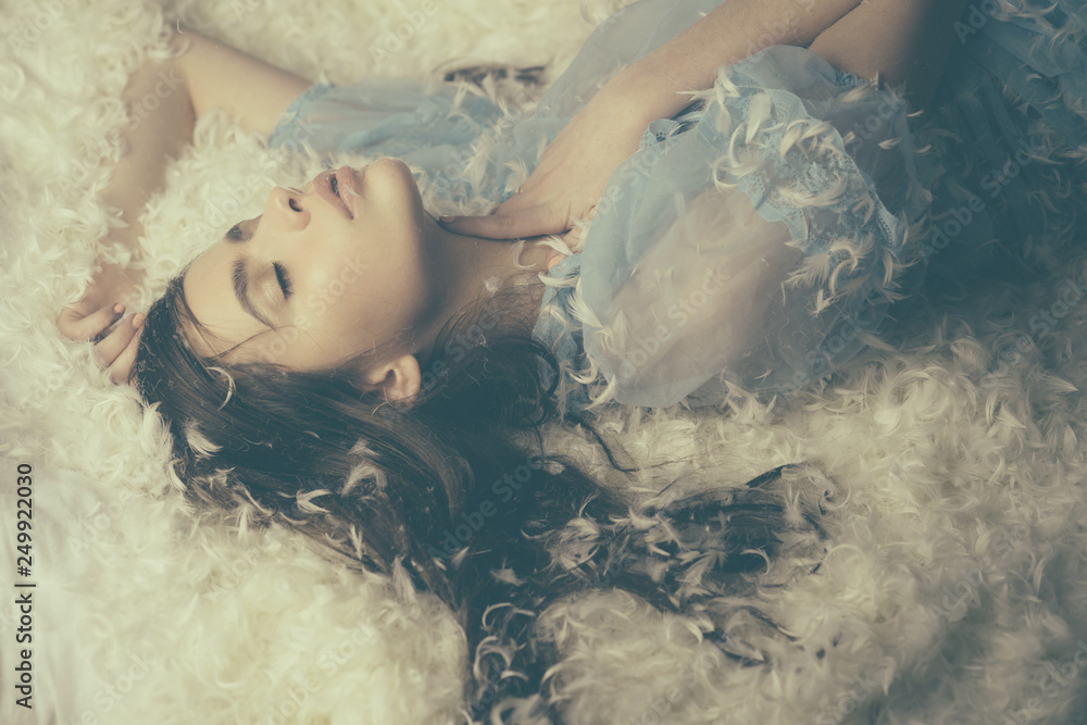 Foto de Sleeping beauty. Cute girl relaxing on feather bed pillow and ...