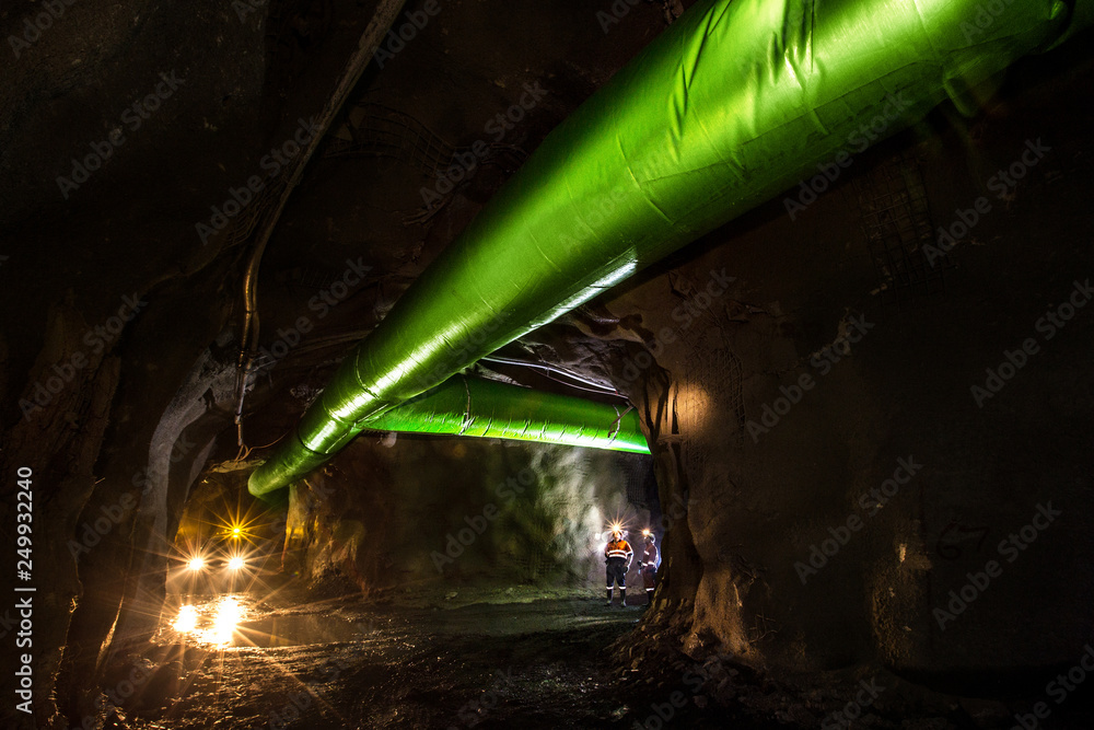 Miners inspecting an underground ventilation system in a gold mine in ...