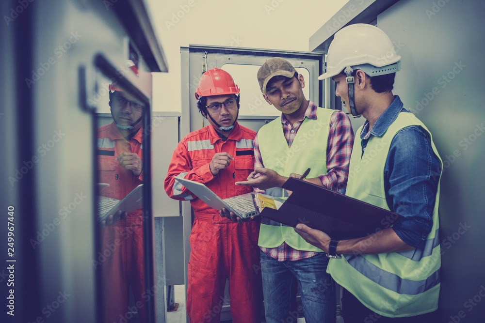 engineer or electrician holding laptop for inspect and checking main ...