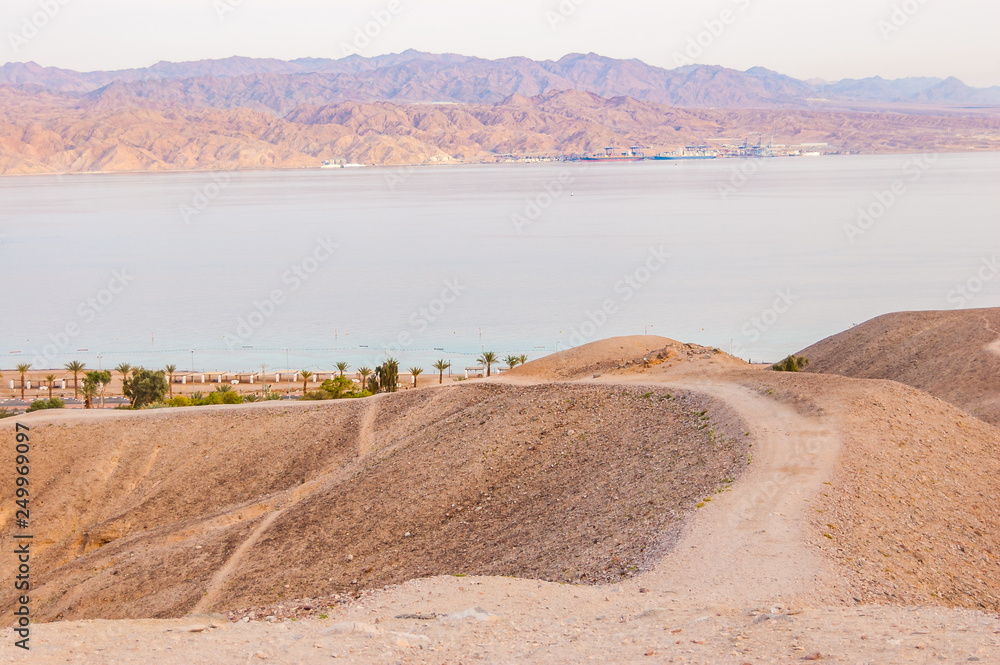 Sandy curved walking pathway from the desert mountains down to the Red ...