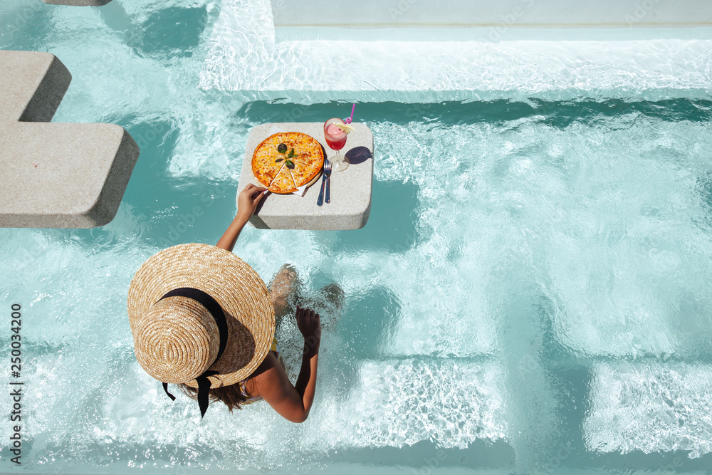 Girl eating pizza in pool Stock Photo | Adobe Stock
